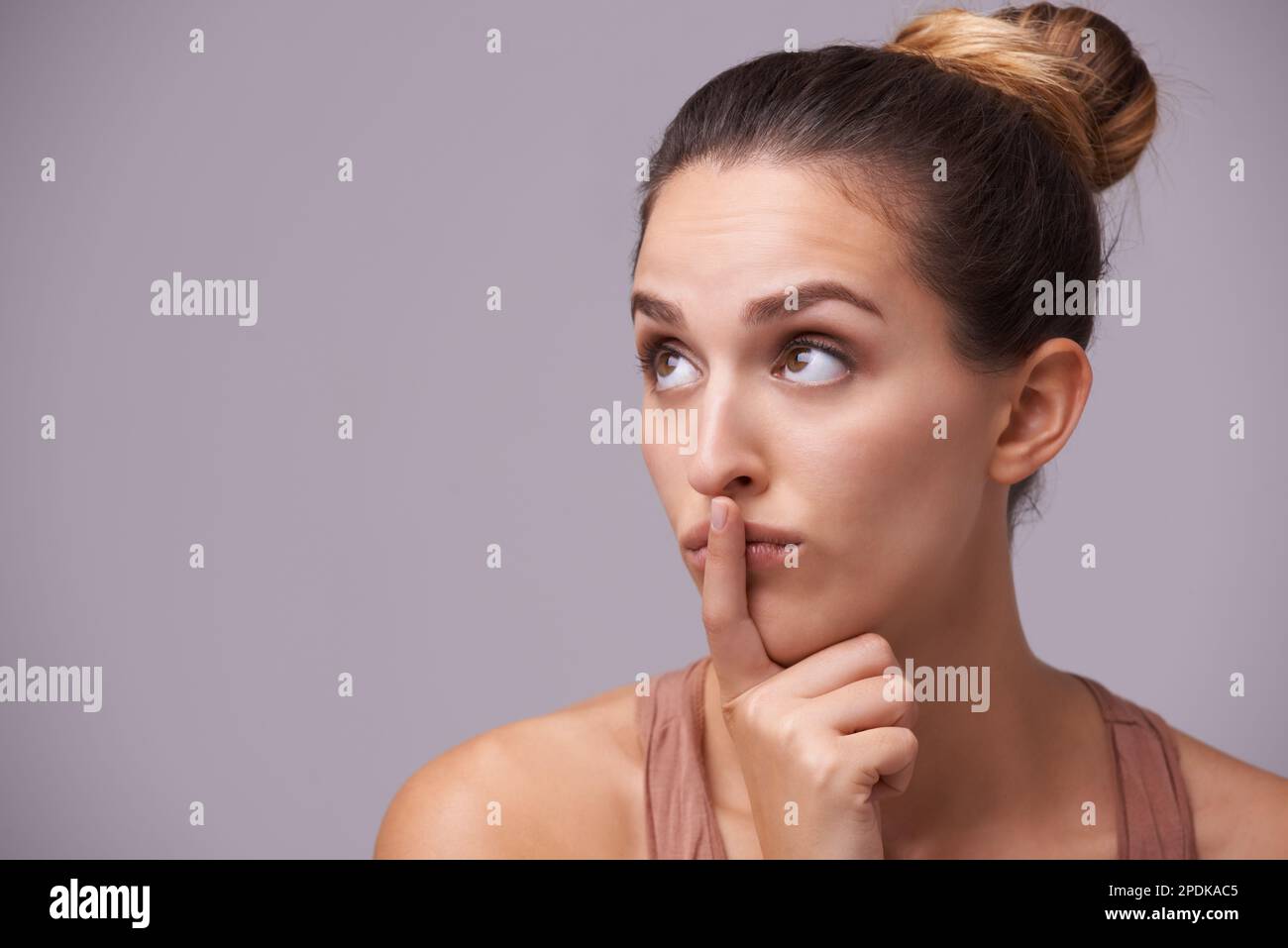 I can keep a secret. An attractive young woman against a purple ...