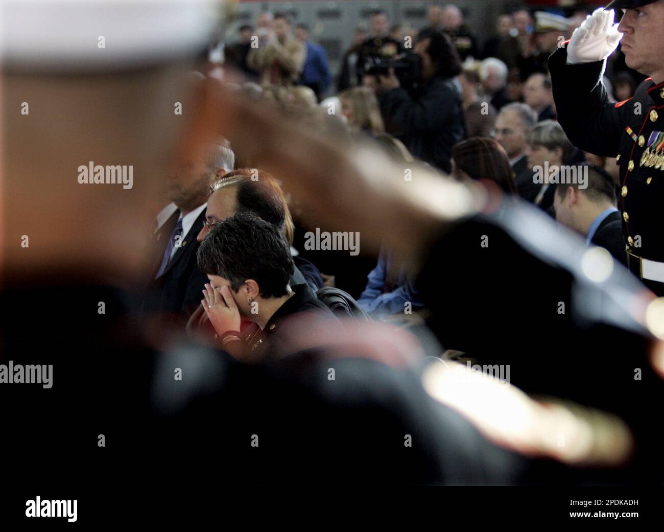 Angie Giannopoulos is framed by a Marine saluting as taps are played at ...