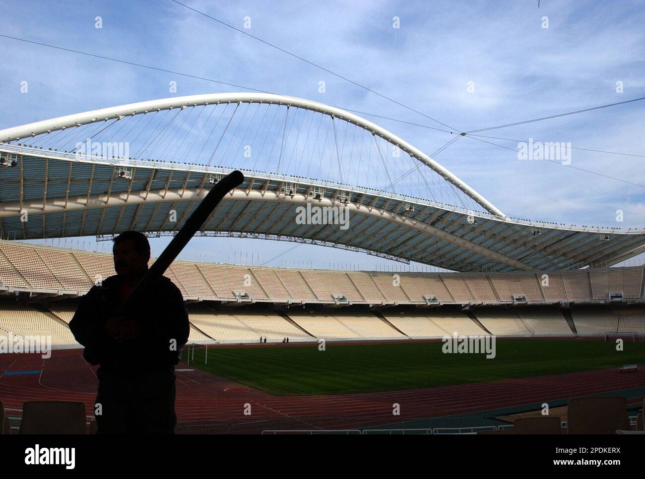 A worker cleans the seats at the Olympic stadium of Athens as the glass ...
