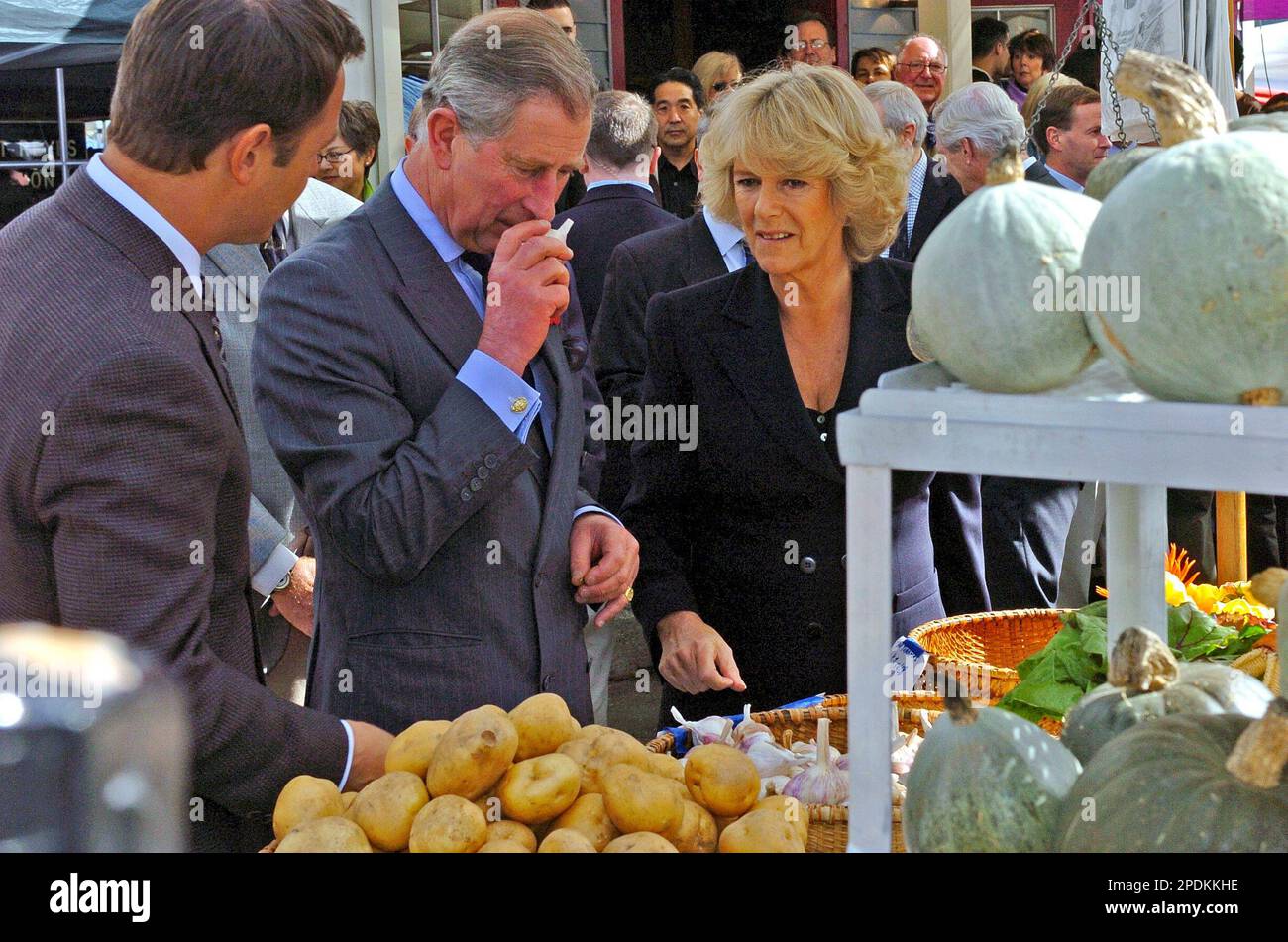 Britain's Prince Charles, center, smells an organic garlic clove as his ...