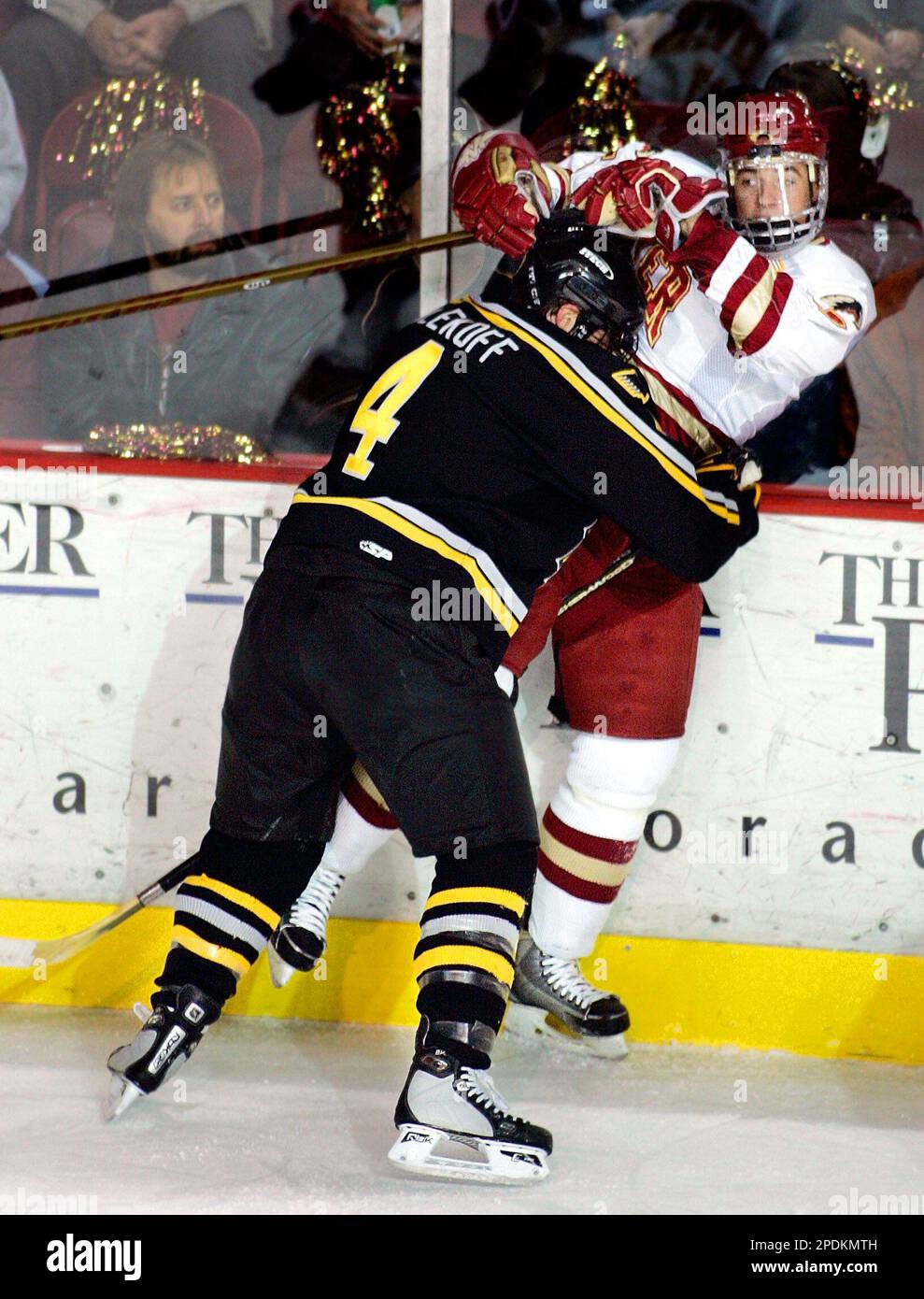 Michigan Tech defenseman Mark Malekoff (4) checks Denver defenseman ...