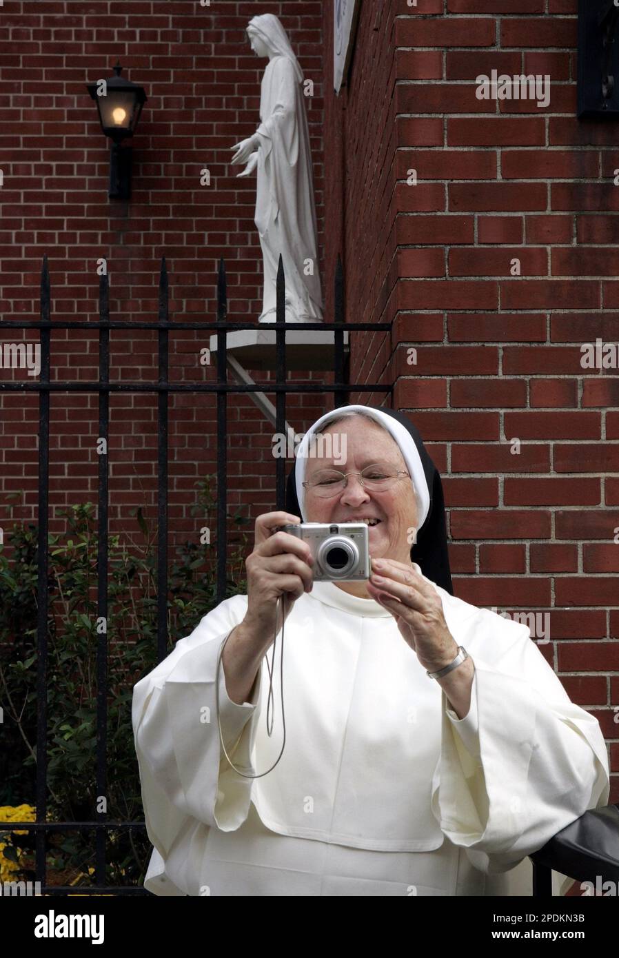 Sister Joan Marie takes a picture of the crowd gathered to see Britain ...