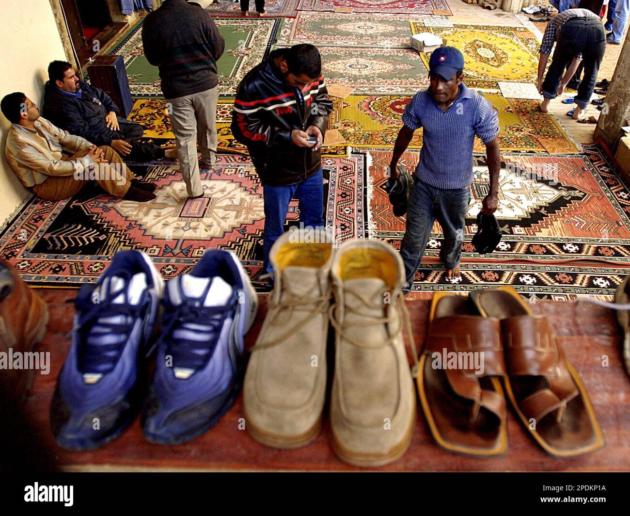 Muslim immigrants take off their shoes outside a mosque during Friday ...
