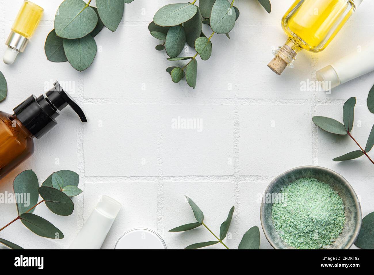 Eucalyptus, towel, massage salt, aroma oil, spa objects on white tile ...
