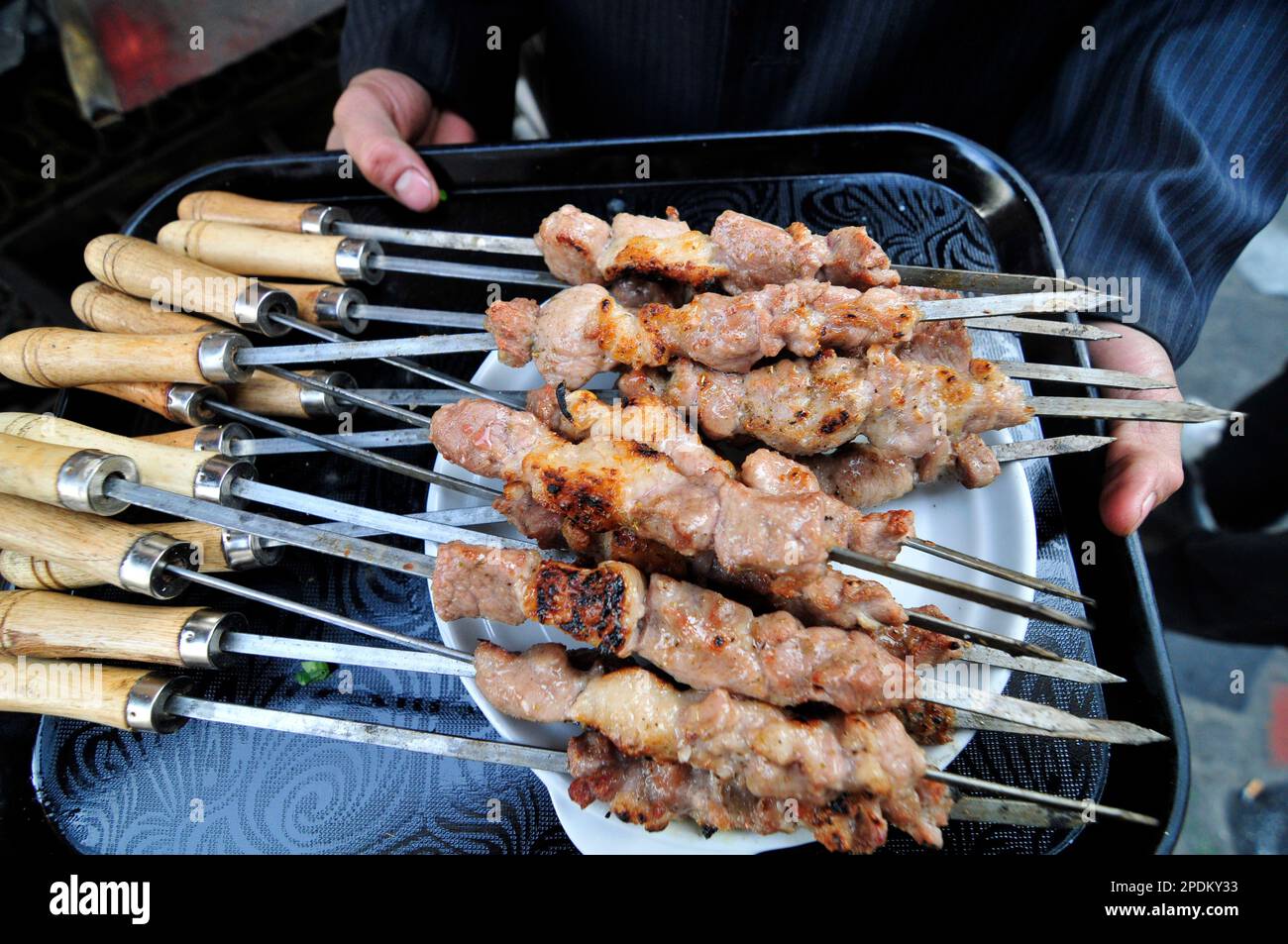 An Uyghur man grilling kebabs ( meat skewers ) in the old city of ...