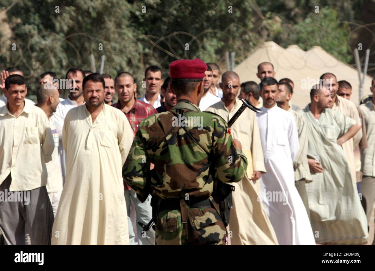 An Iraqi army soldier guards prisoners before their release, in Baghdad ...