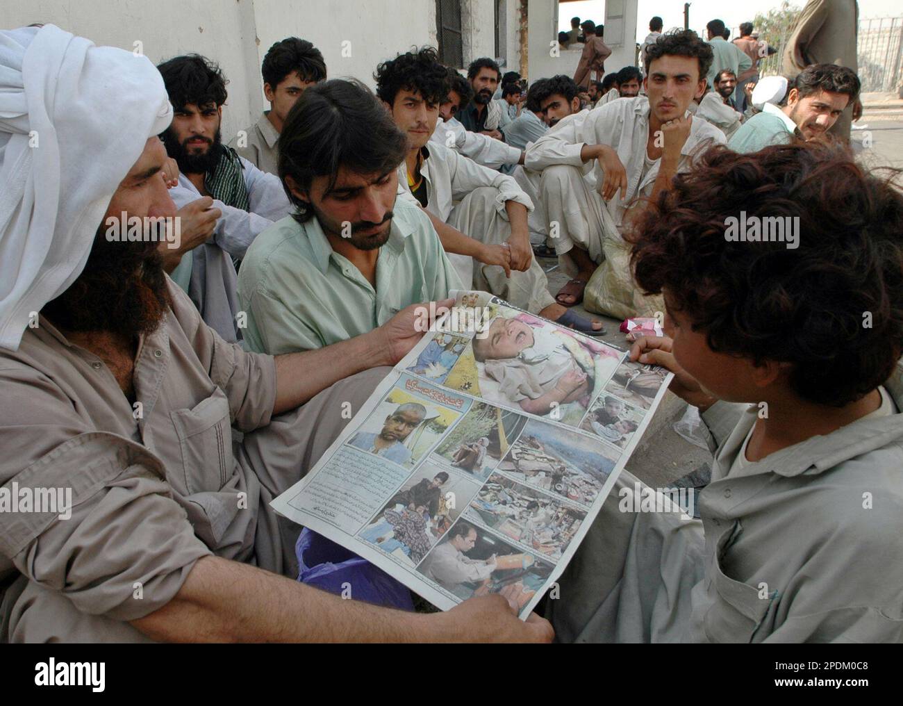 Pakistanis who are deported from Oman for their illegal entry look at a ...
