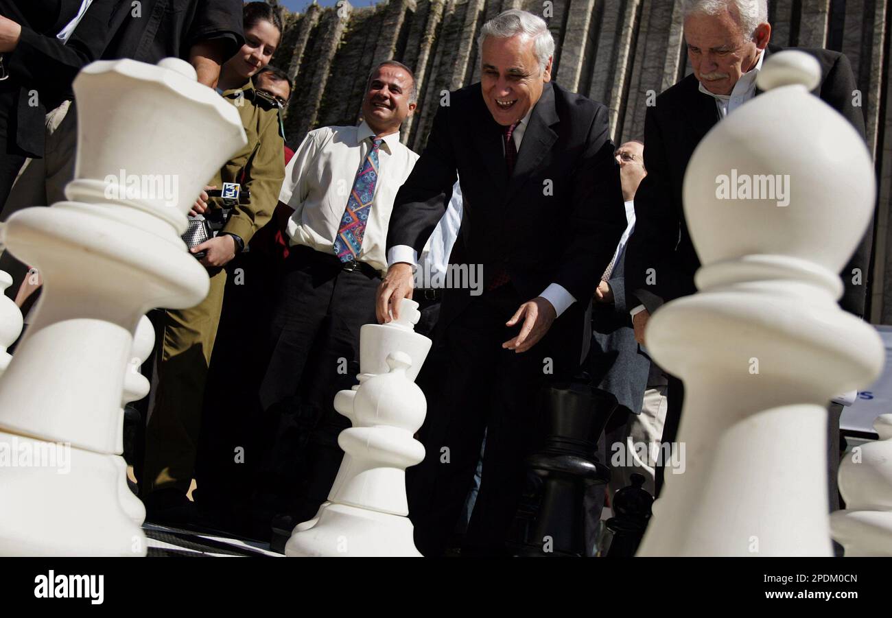 Israeli President Moshe Katsav, center, moves a chess piece during the ...