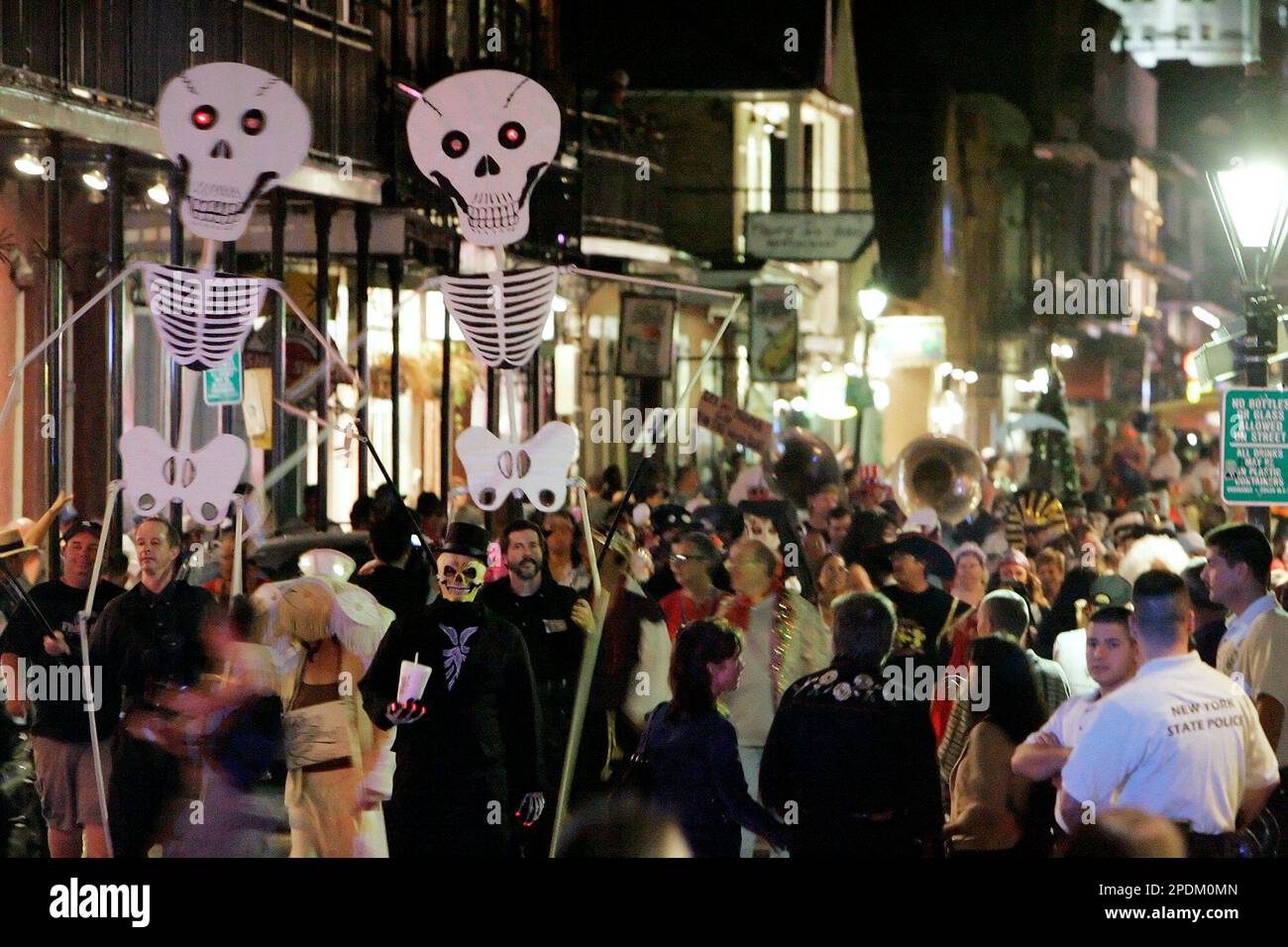 Crowds in costumes stroll along Bourbon Street in the French Quarter of ...