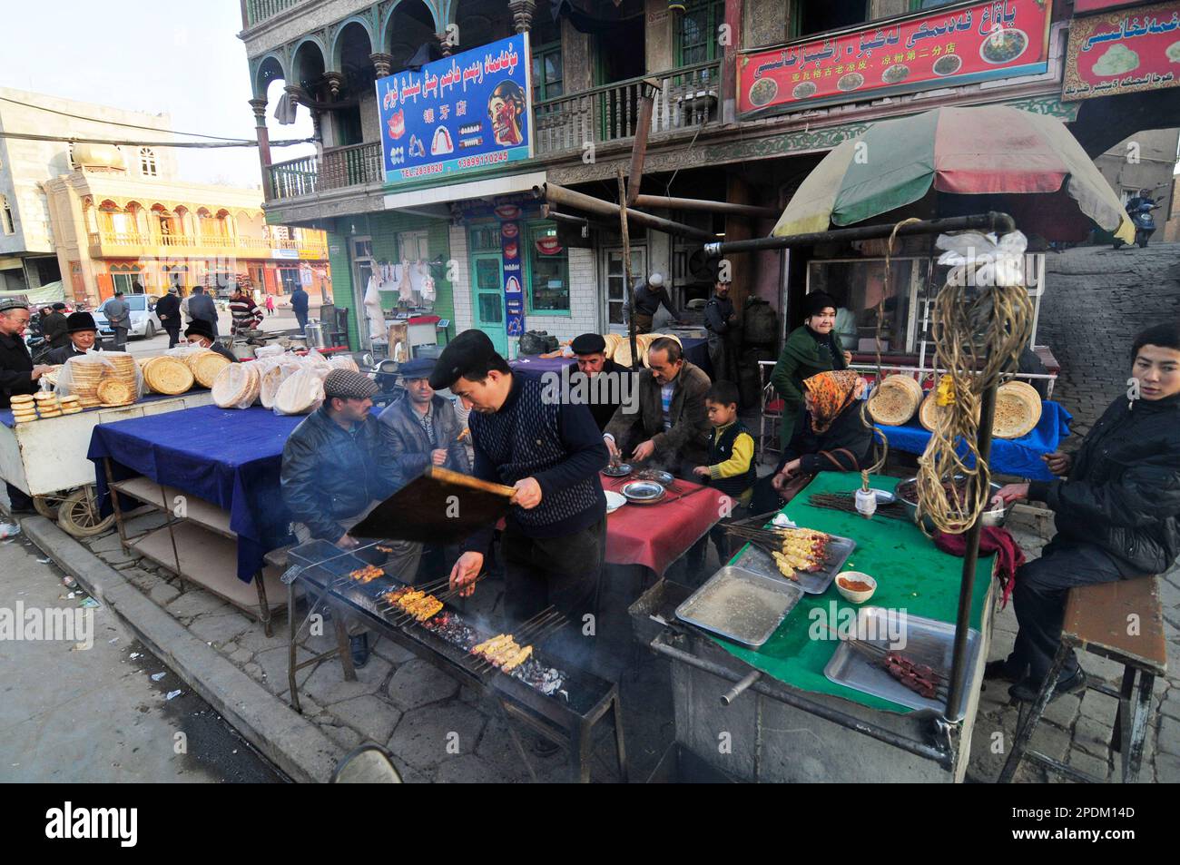 An Uyghur man grilling kebabs ( meat skewers ) in the old city of ...