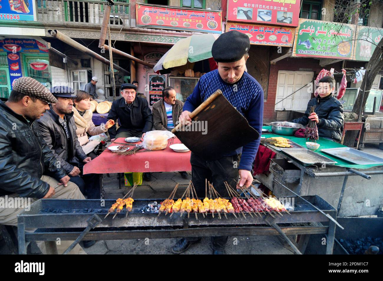 An Uyghur man grilling kebabs ( meat skewers ) in the old city of ...
