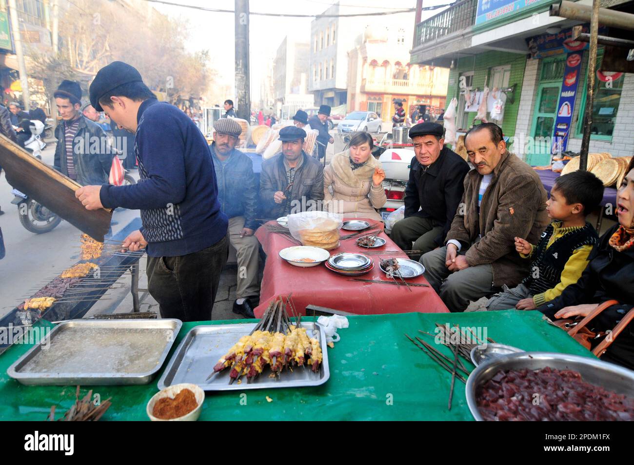 An Uyghur man grilling kebabs ( meat skewers ) in the old city of ...