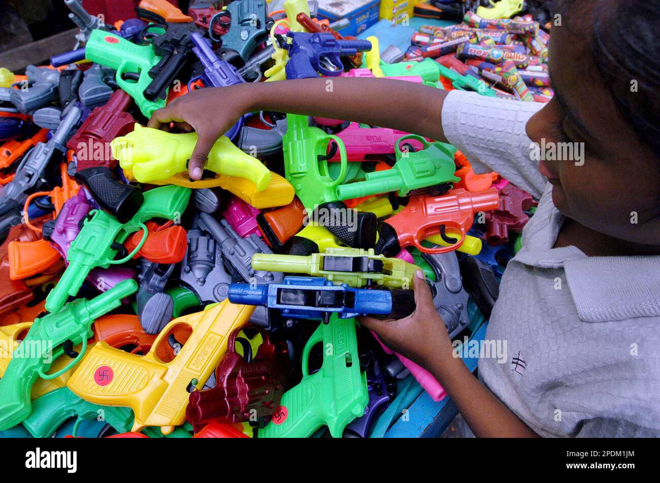 Amlu, 7, looks at toy guns at a shop in Madras, India, Monday, October 31, 2005. Indians across ...