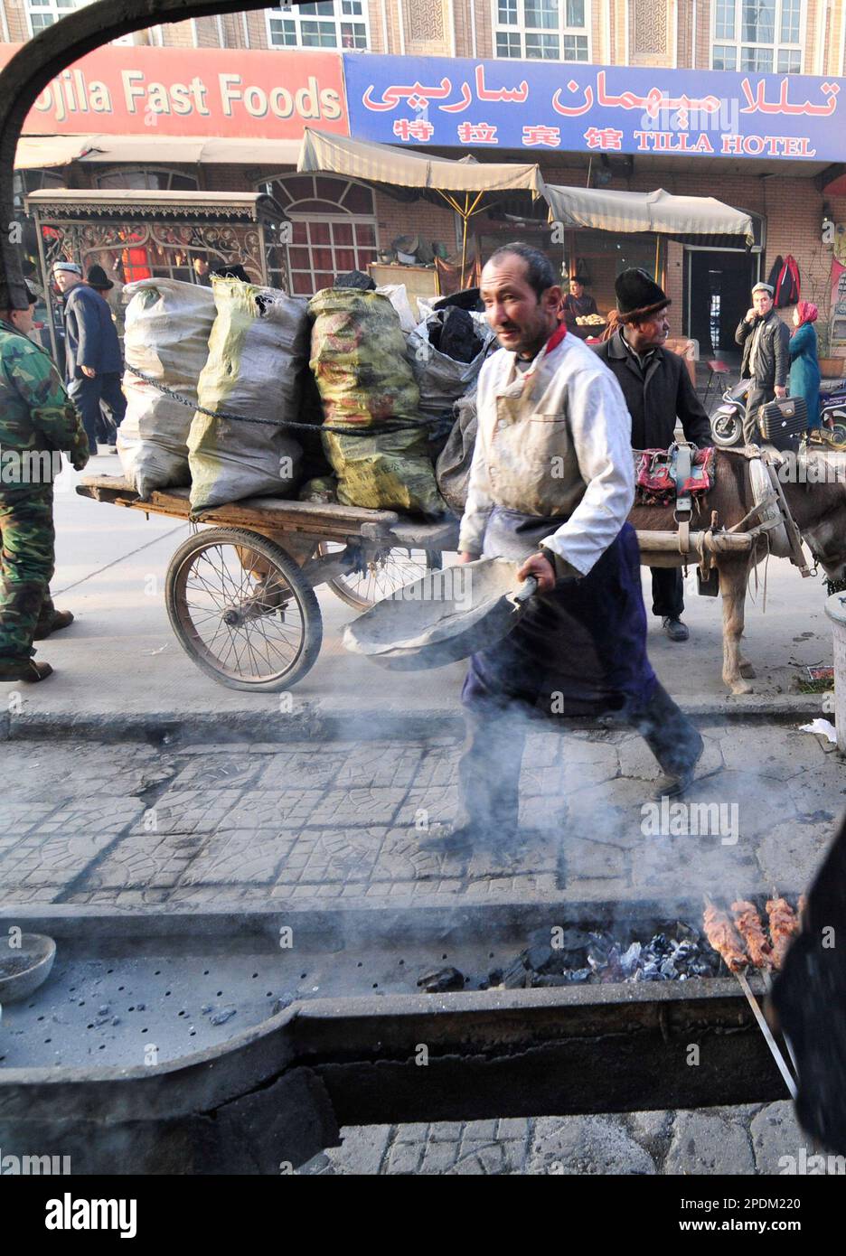 An Uyghur man grilling kebabs ( meat skewers ) in the old city of ...