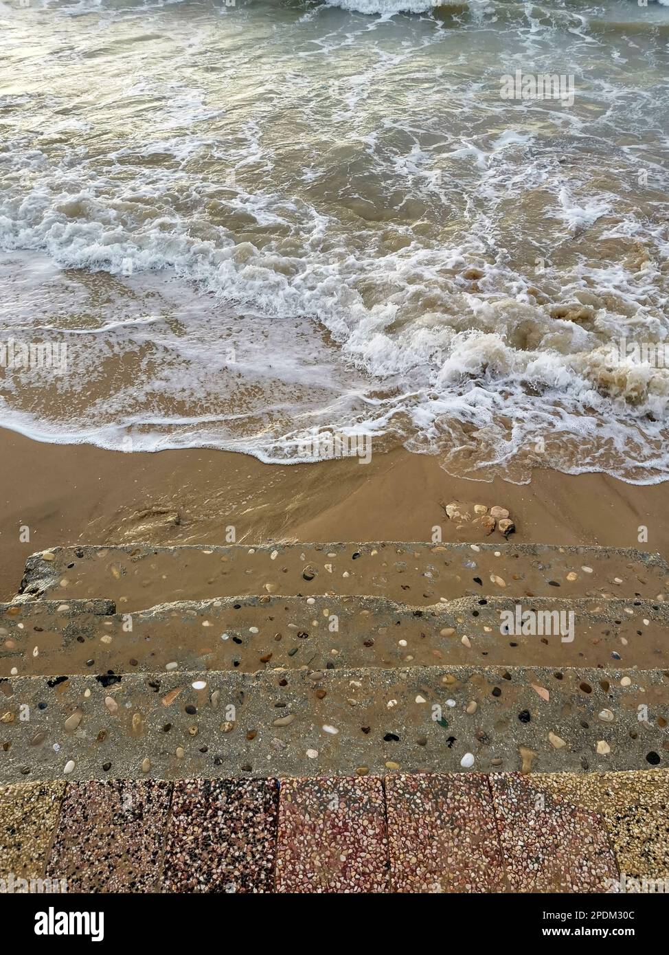 Ancient stone stairs descend to sandy beach to sea waves Stock Photo ...