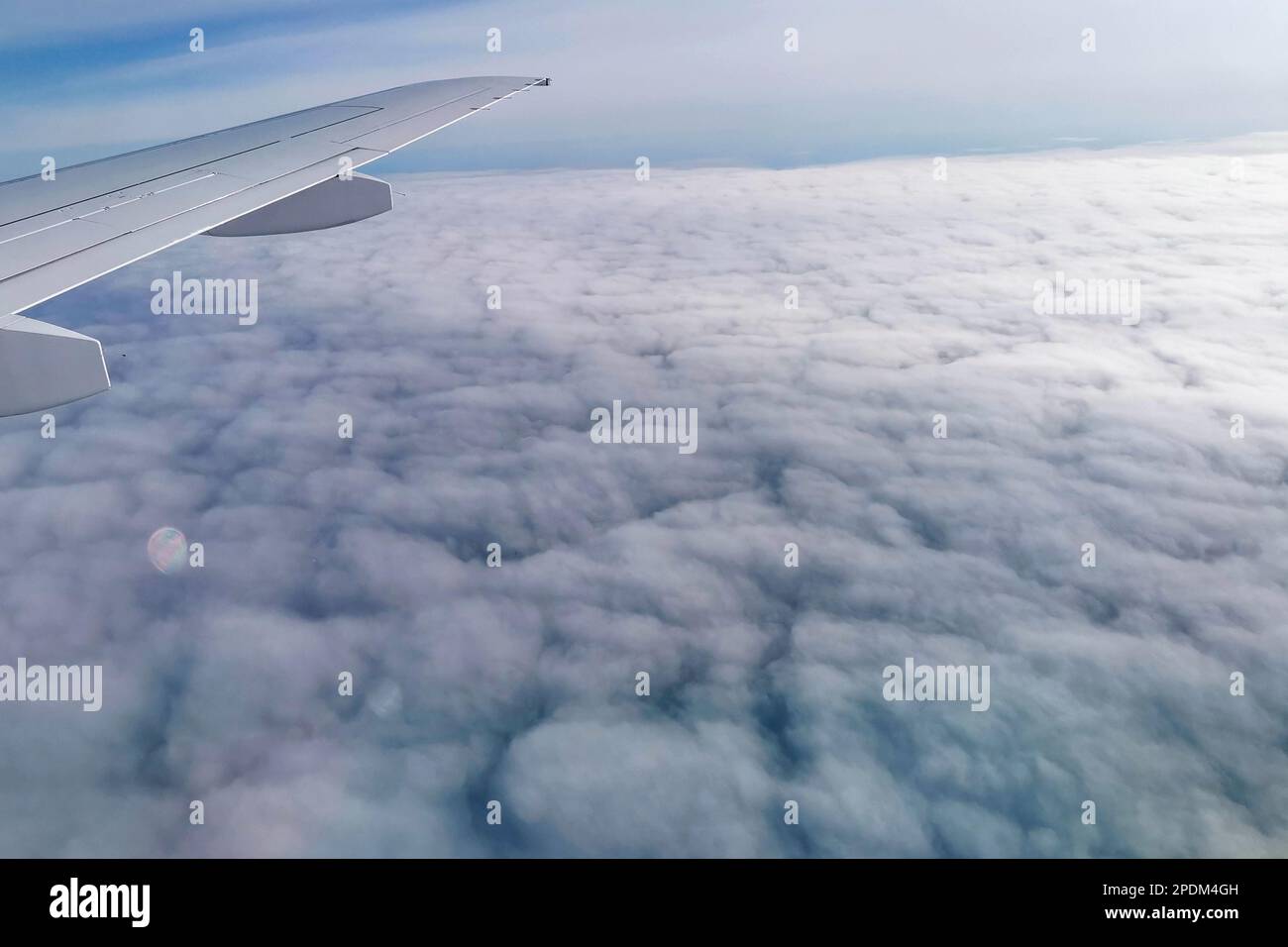 Plane is landing. Airplane wing over clouds. Aerial view through window ...