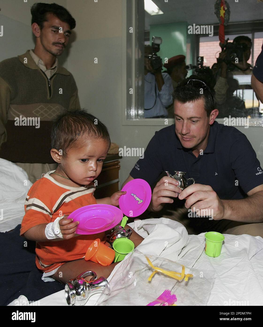 England player Ashley Giles plays with an infant victim of the South ...