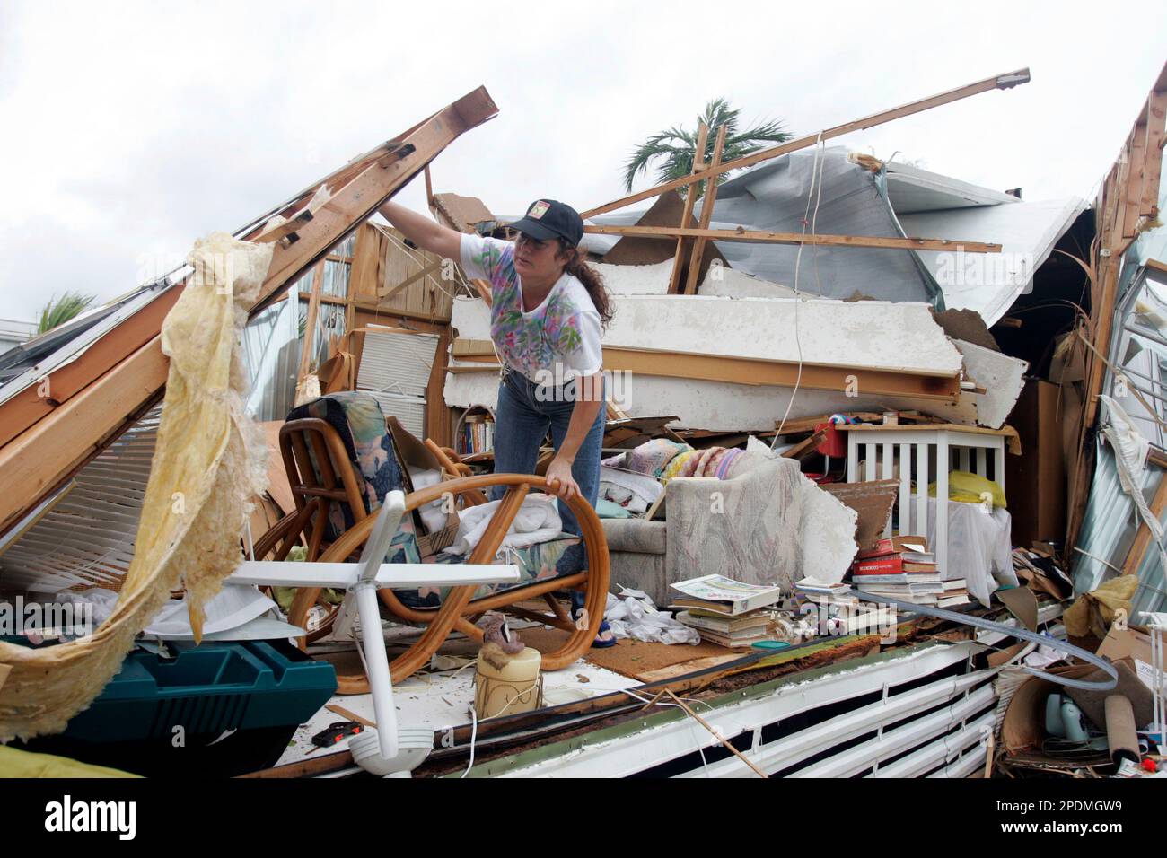 Jeannie Berg pushes part of her mobile home frame aside as she tries to ...