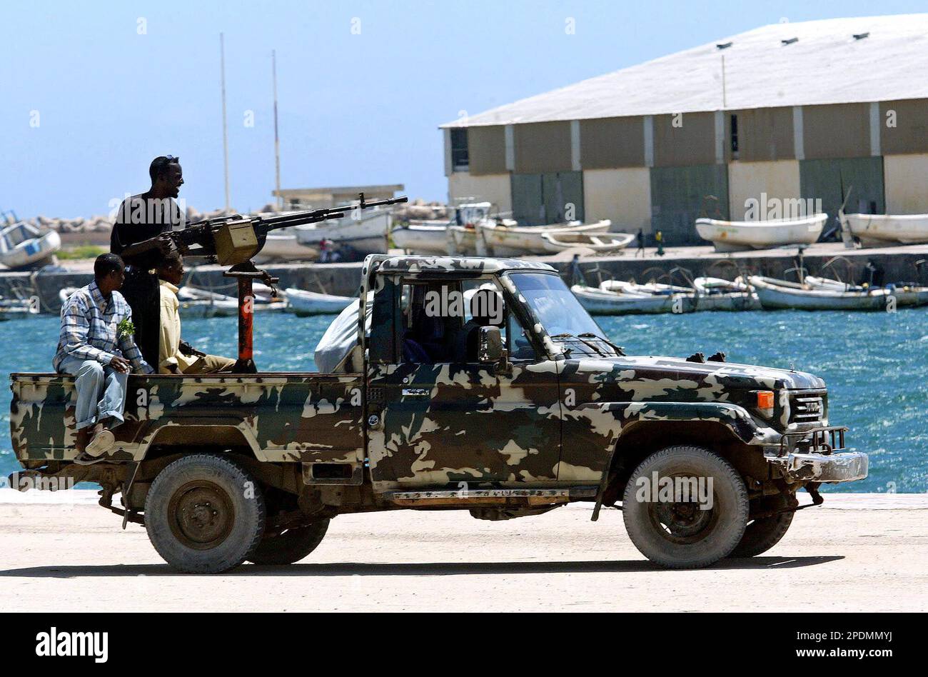 ** FILE ** Gunmen patrol the harbour in Somali capital, Mogadishu in ...
