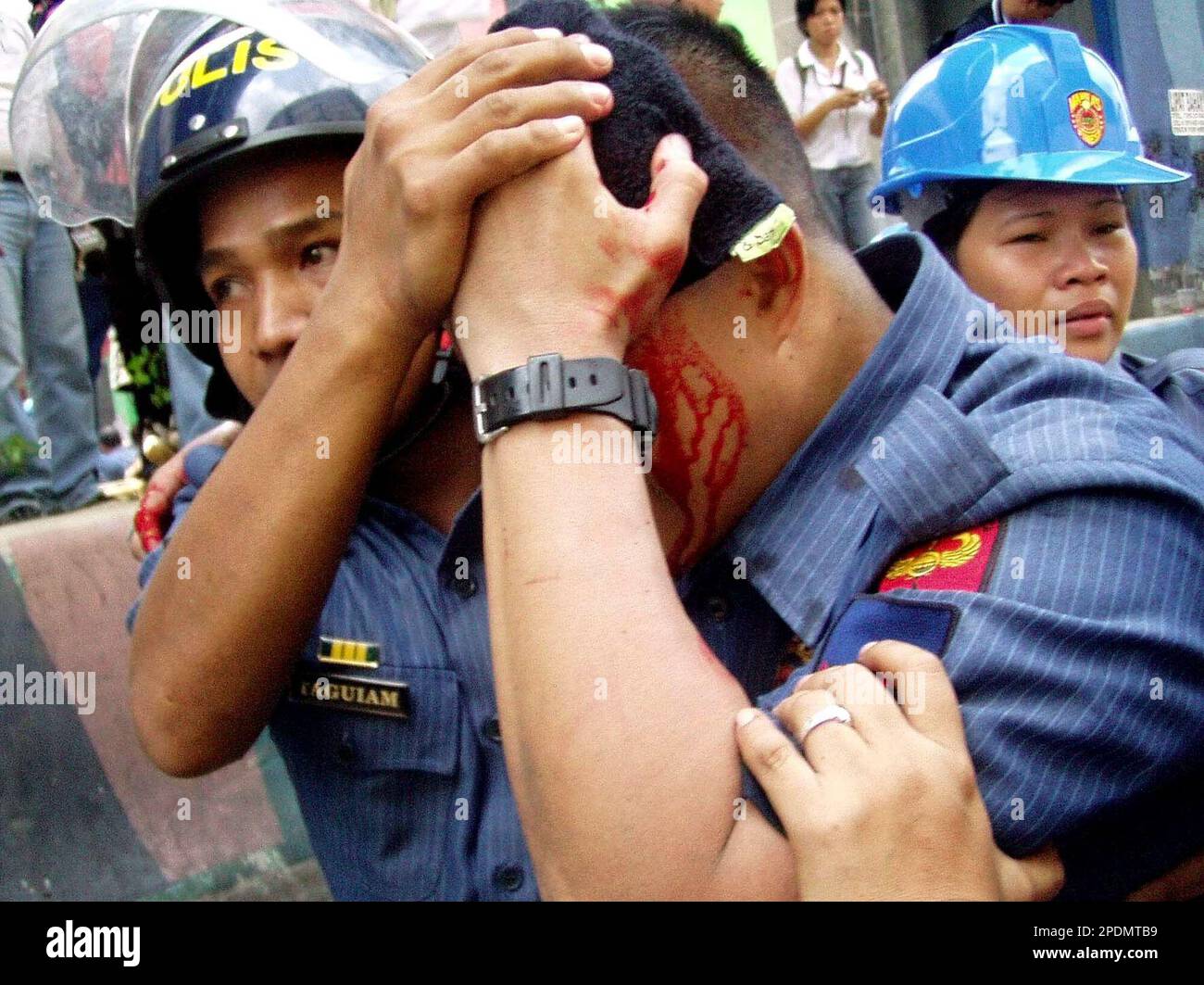 A police covers the head of his colleague who was hurt during a scuffle ...