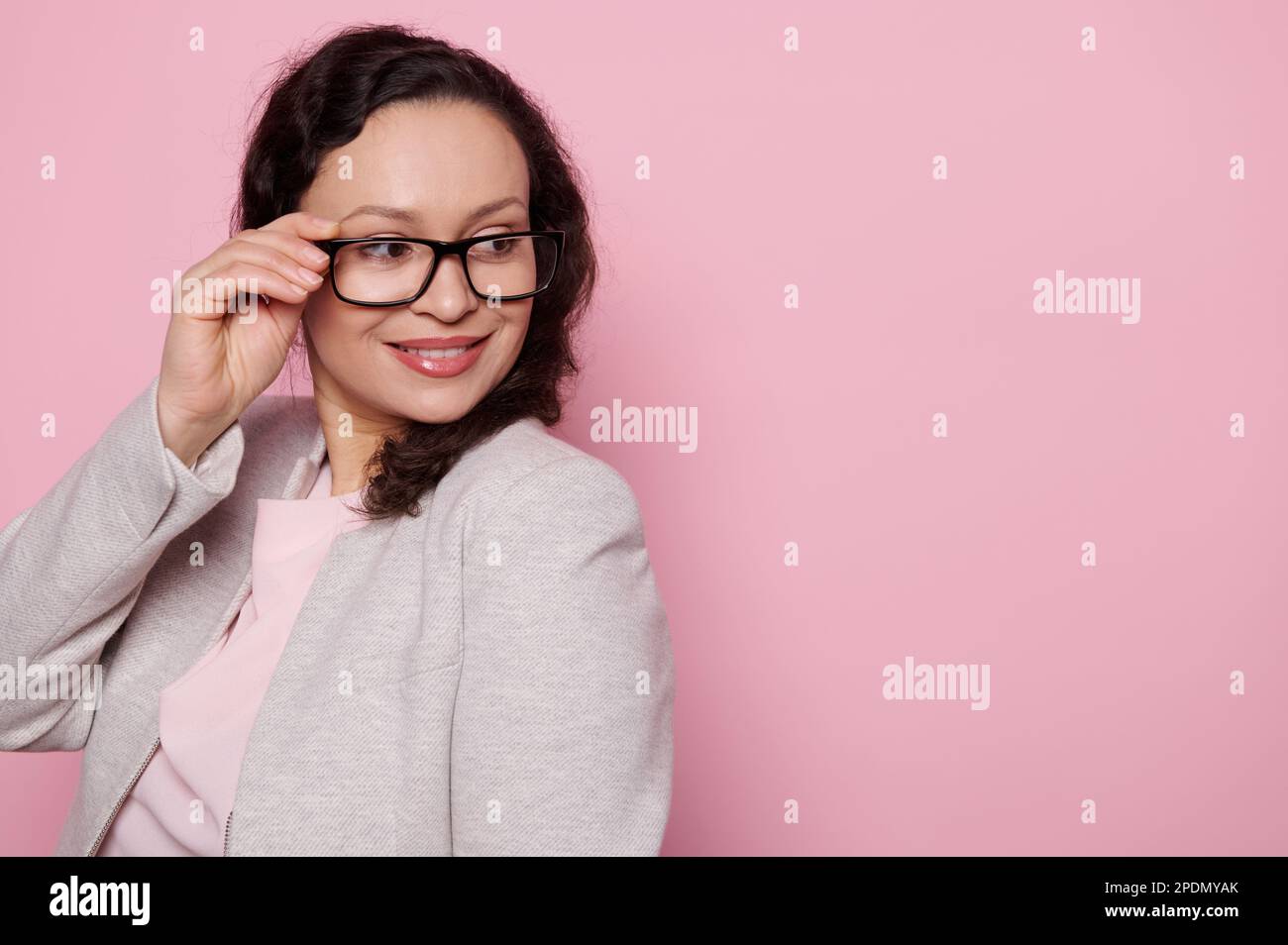 Gorgeous woman, wearing black frame glasses, smiling looking aside at ...