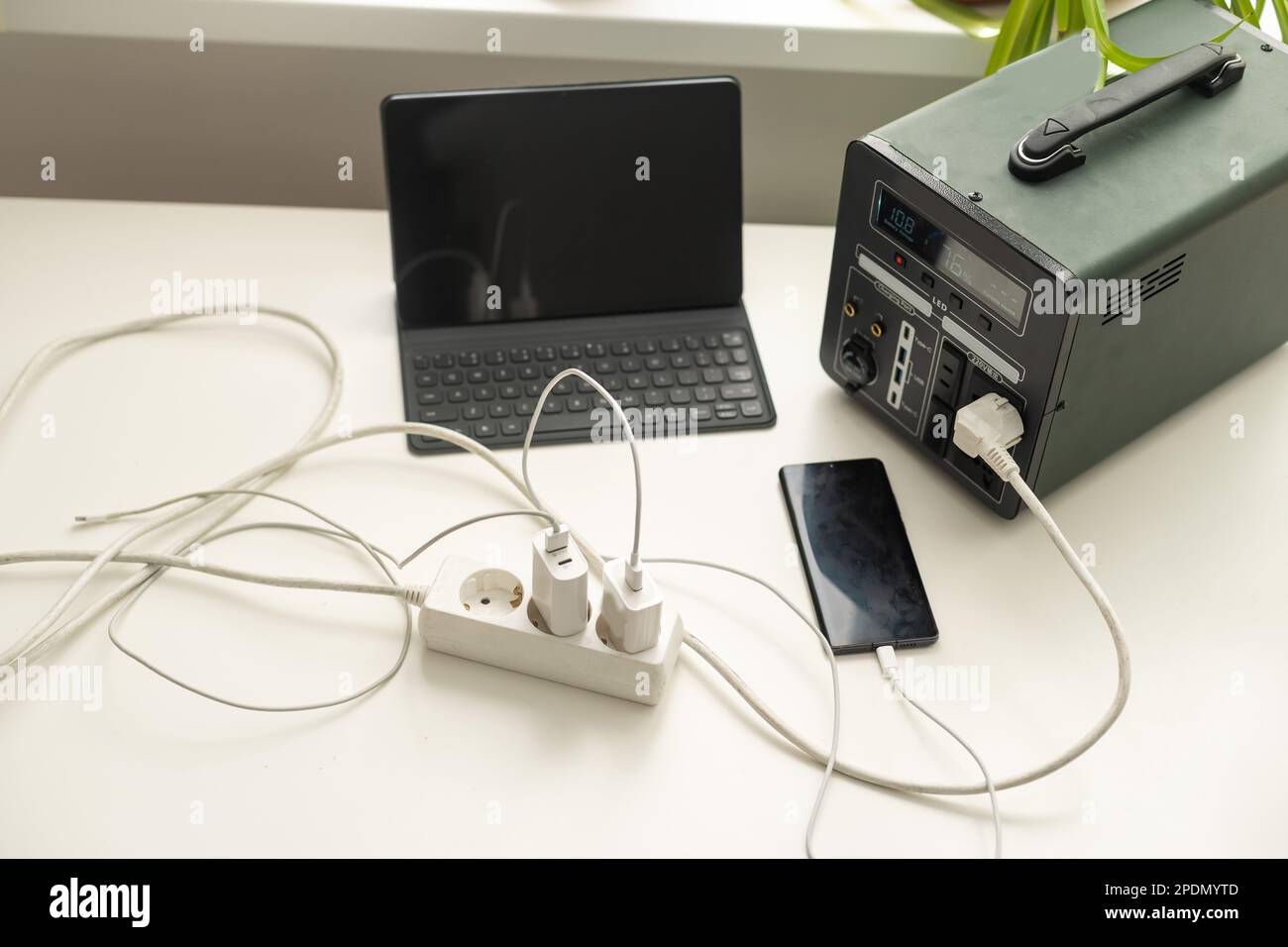 Portable power station charging gadgets near wall Stock Photo - Alamy
