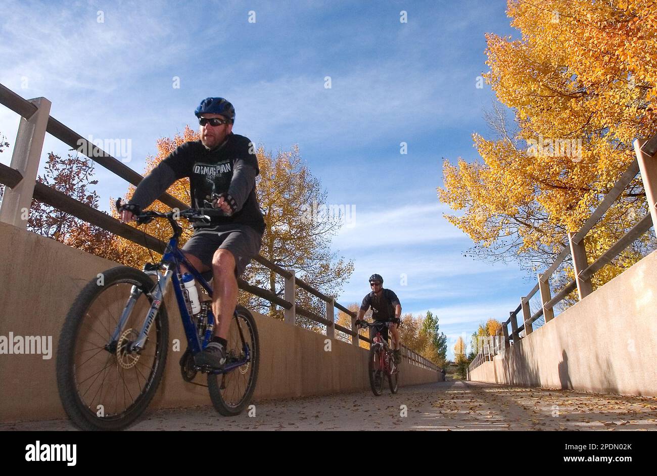 Bicycle riders cross the Marolt Bridge over the Maroon Creek in Aspen ...