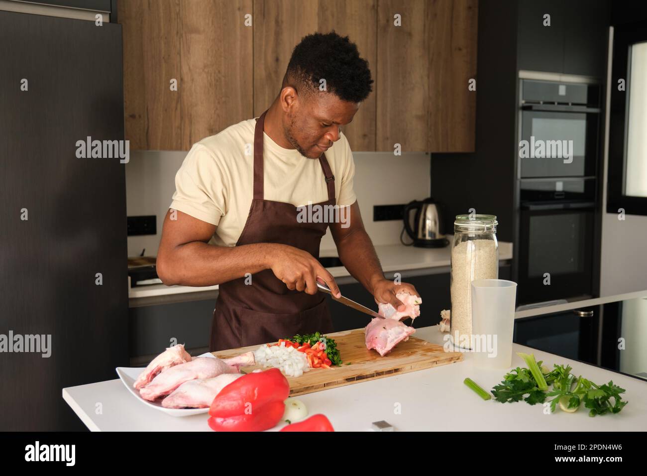 Young black man removing the skin from chicken to prepare a recipe ...