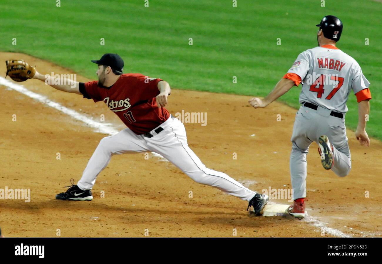 Houston Astros first baseman Lance Berkman stretches to glove the relay ...