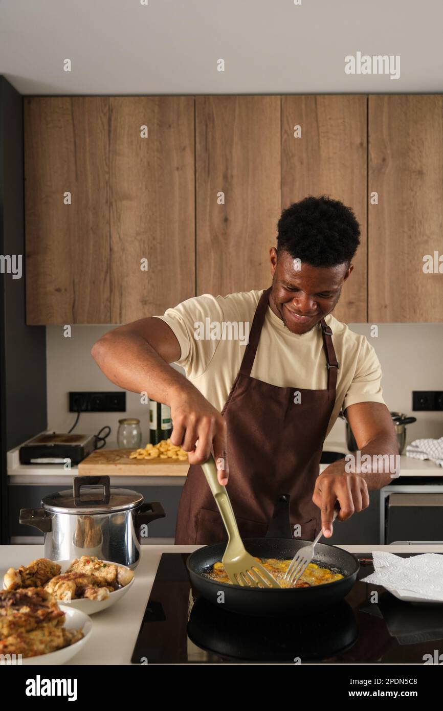 Young black man frying plantains slices Stock Photo - Alamy