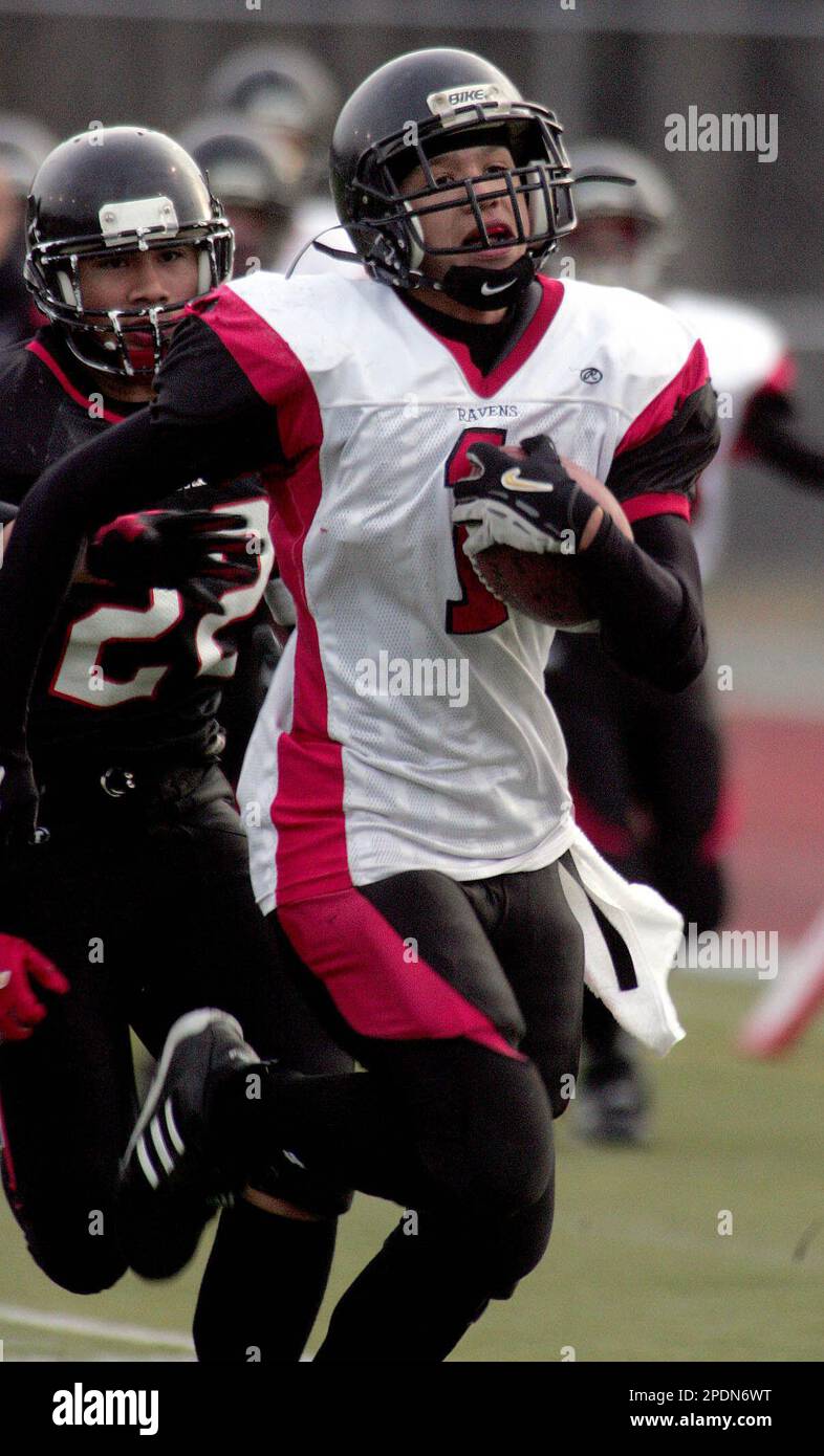 Ben Eielson's Travis Pew (1) runs past Kenai's Bill Chimphalee (22 ...