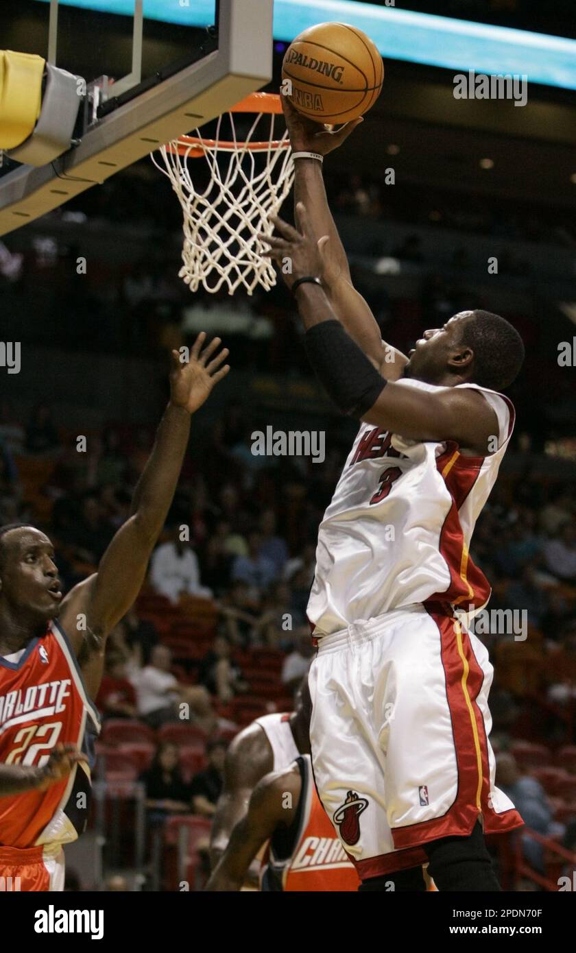Miami Heat guard Dwyane Wade, right, goes up for a shot as Charlotte ...