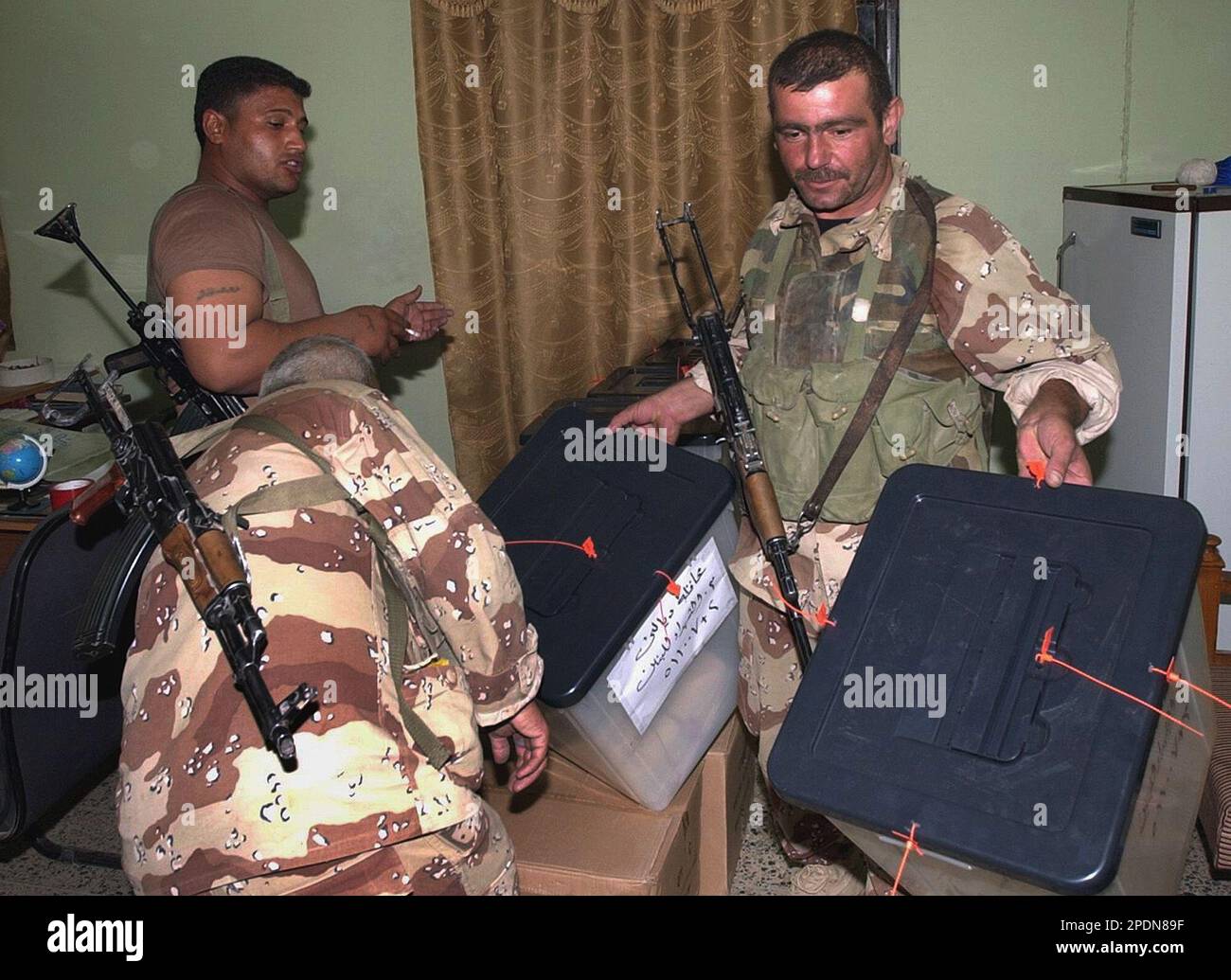 Iraqi soldiers carry ballot boxes at the end of the voting day, in ...