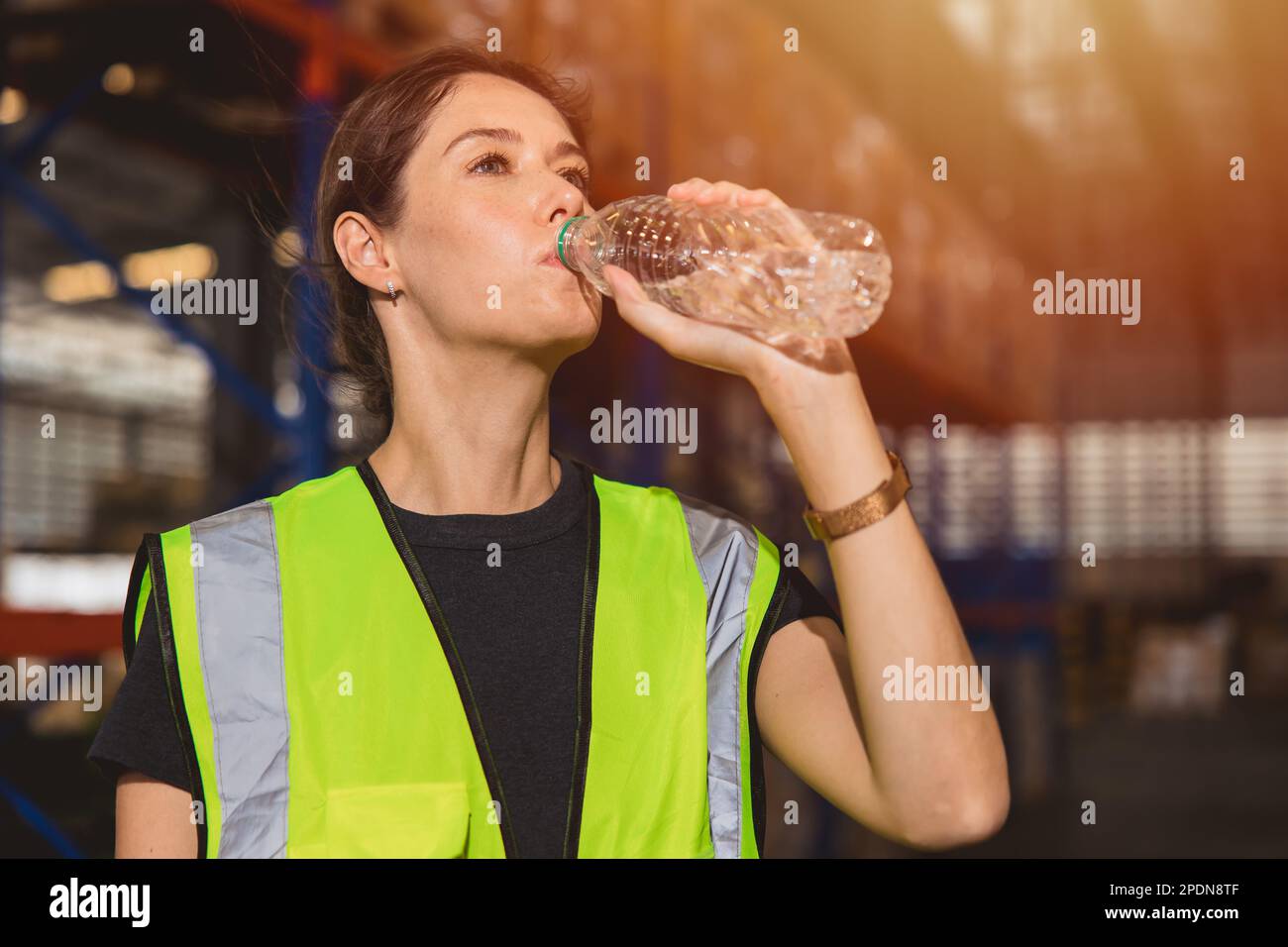 health care woman worker drinking clean water while working in hot place for refresh and ...