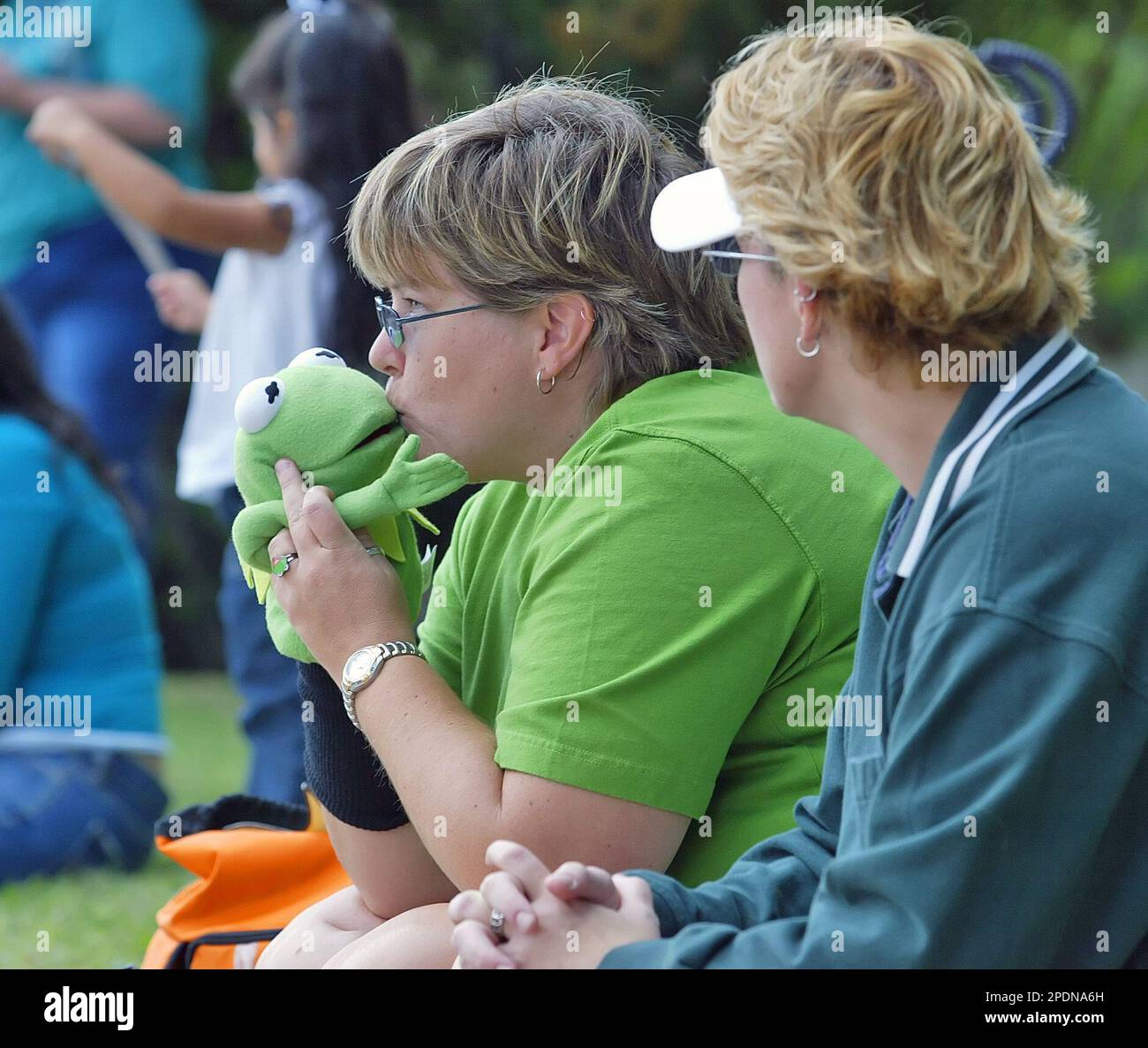 Victoria Geist, left, kisses her Kermit the Frog golf club head cover ...
