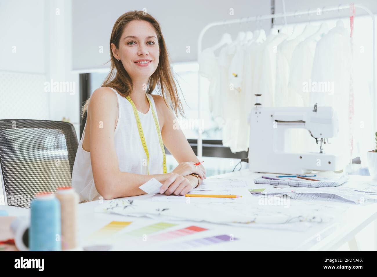 Beautiful female dressmaker sitting in hi-res stock photography and ...