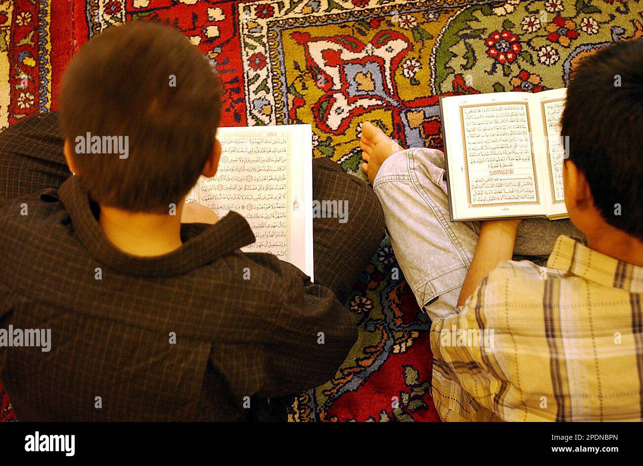 Two Syrian Muslim boys reading the Quran, Muslim's Holy book, before ...