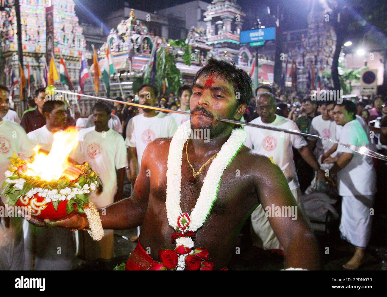 A Hindu devotee pierced with metal rod through his mouth parades in ...