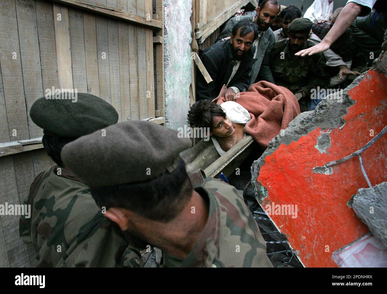 A Pakistani earthquake survivor is pulled from the rubble of a ...