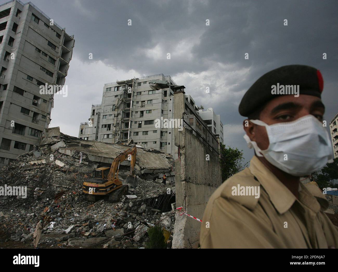 A Pakistan army soldier stands guard in front of the debris of the ...