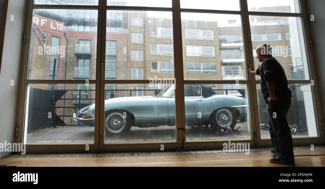 A member of the Design Museum staff awaits the arrival of an E-Type ...