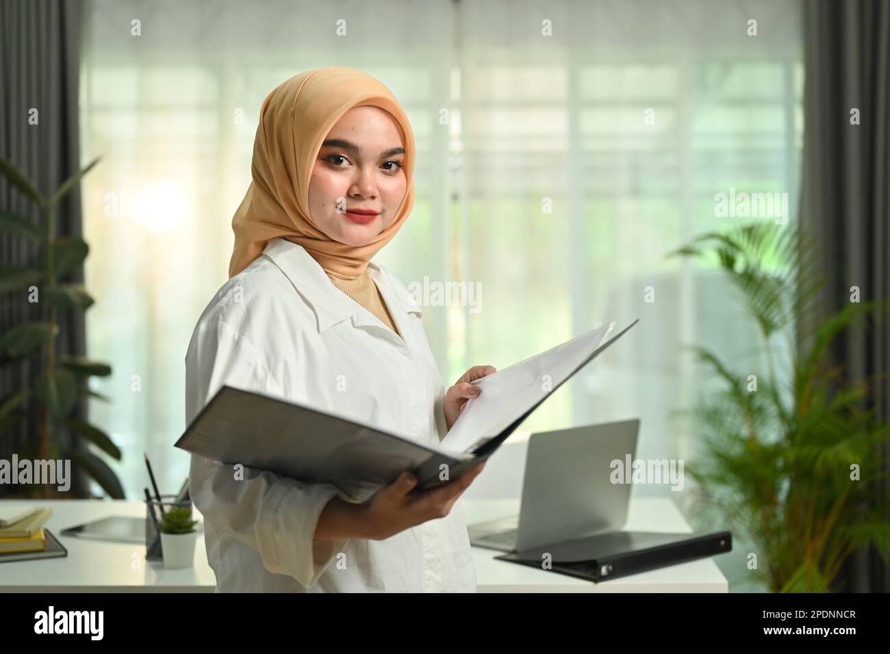 Image of professional muslim woman manger in hijab holding binder and ...