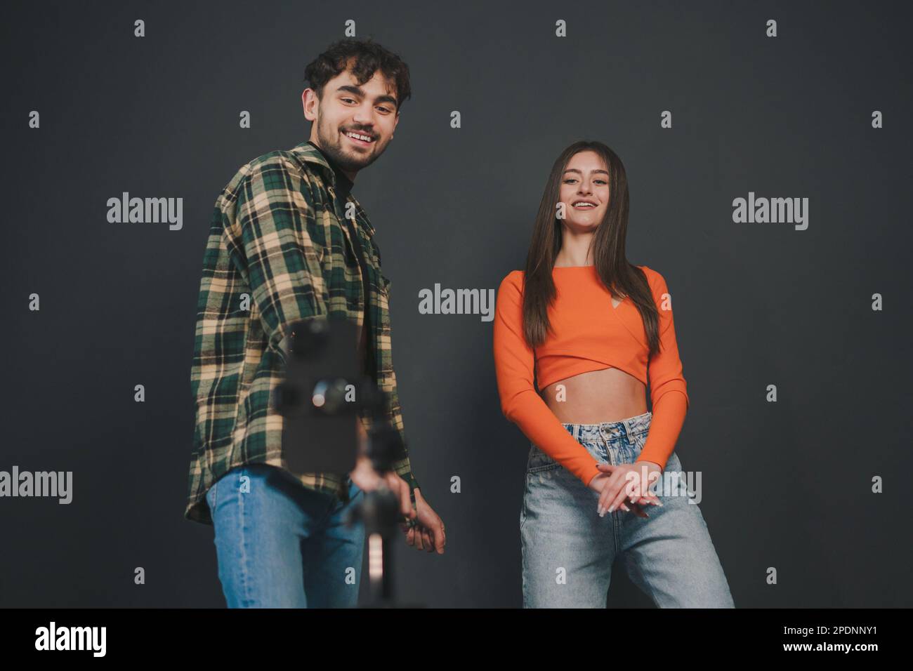 Two young friends having fun recording video reels with mobile phone ...