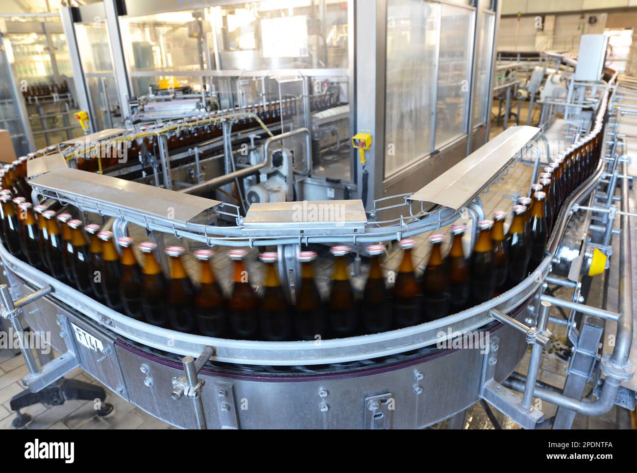 beer bottles on the assembly line in a modern brewery - industrial ...