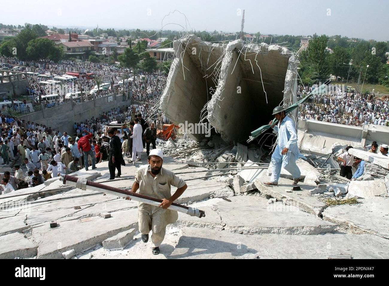 Rescue workers carry stretchers to the collapsed 19-story housing ...