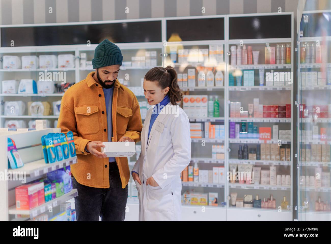 Young pharmacist helping customer to choos medication Stock Photo - Alamy