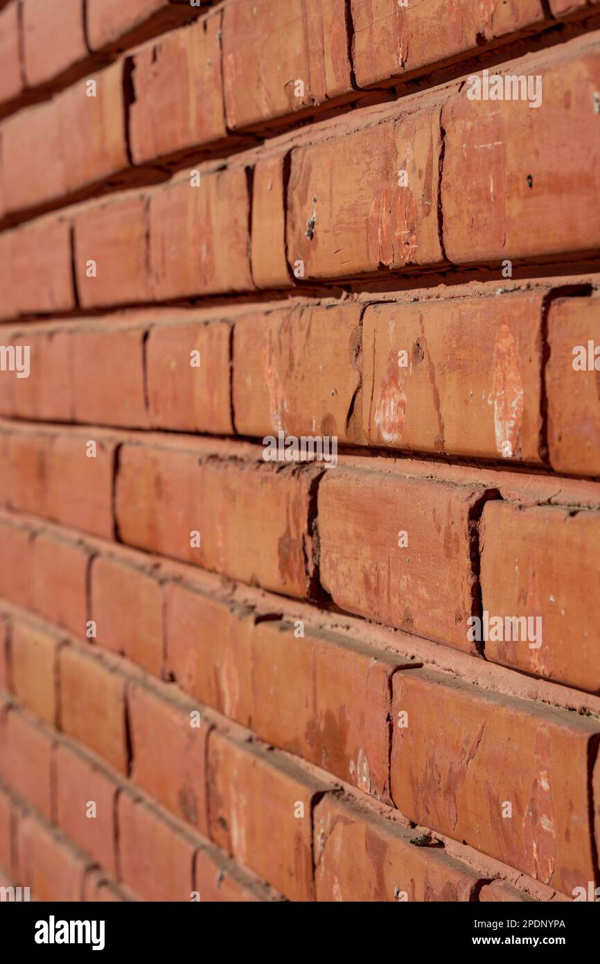 A closeup side view of an orange old brick wall. Architectural ...