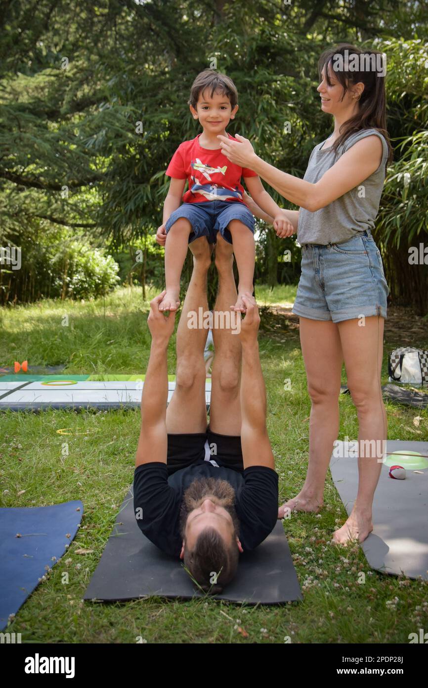 young boy doing a balance exercise with his coaches in the garden Stock ...