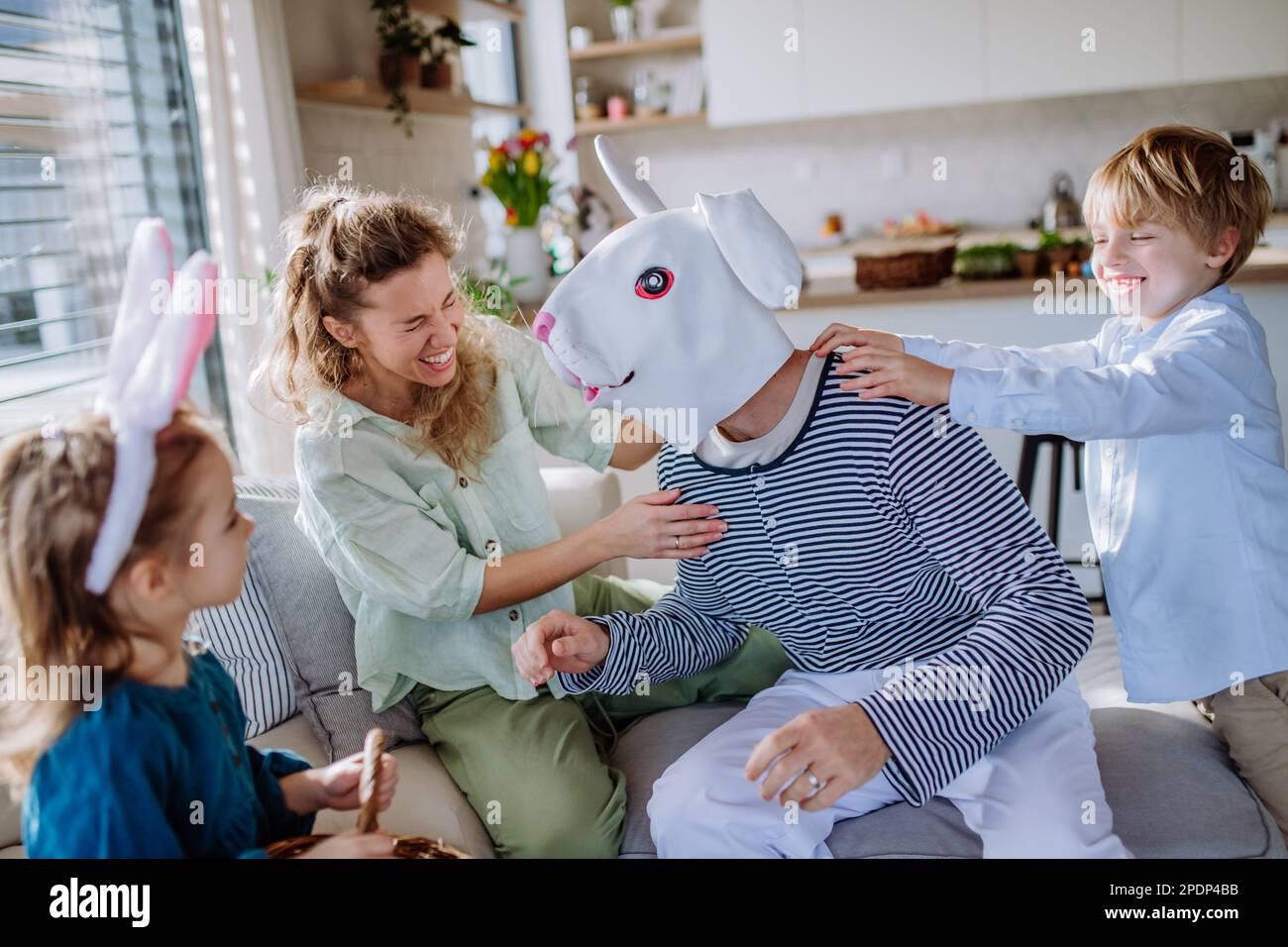 Little children having fun with her mother and Easter rabbit ...