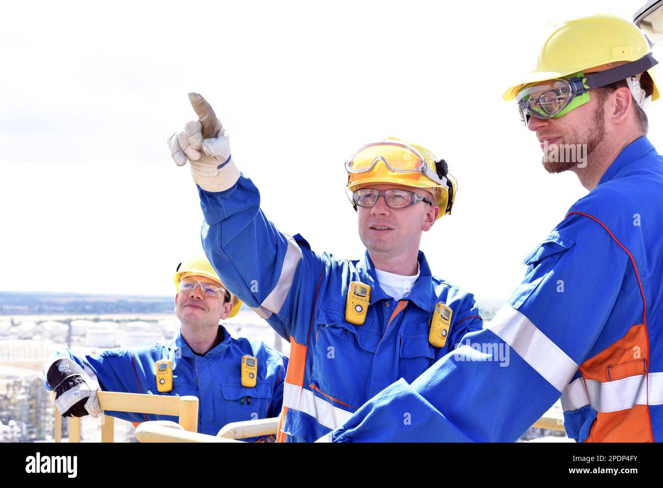 teamwork: group of industrial workers in a refinery - oil processing ...
